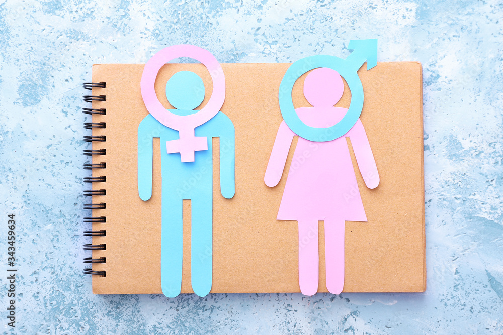 Notebook with figures of man, woman and symbols on color background ...