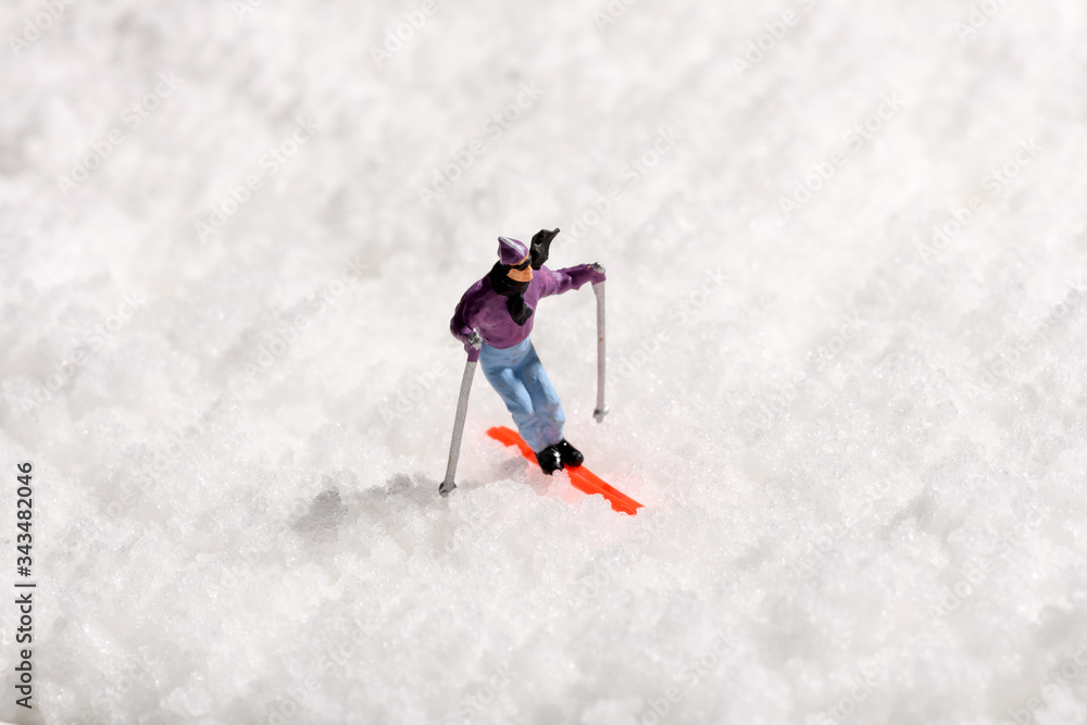 Lone miniature man skiing on fresh winter snow Stock Photo | Adobe Stock