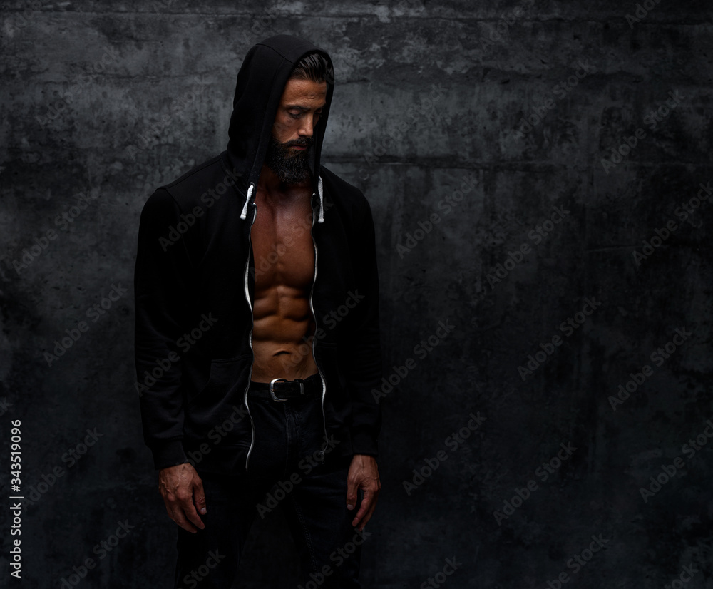 Handsome macho man posing shirtless in unbuttoned coat with hood ...