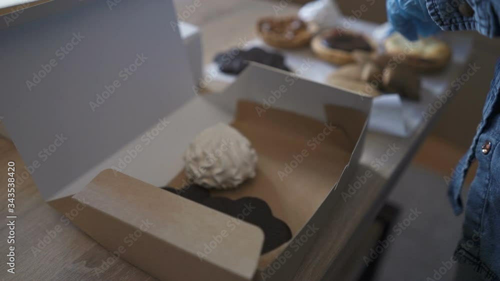 Homemade pastry delivery. Cake shop business. Woman putting cupcakes in ...