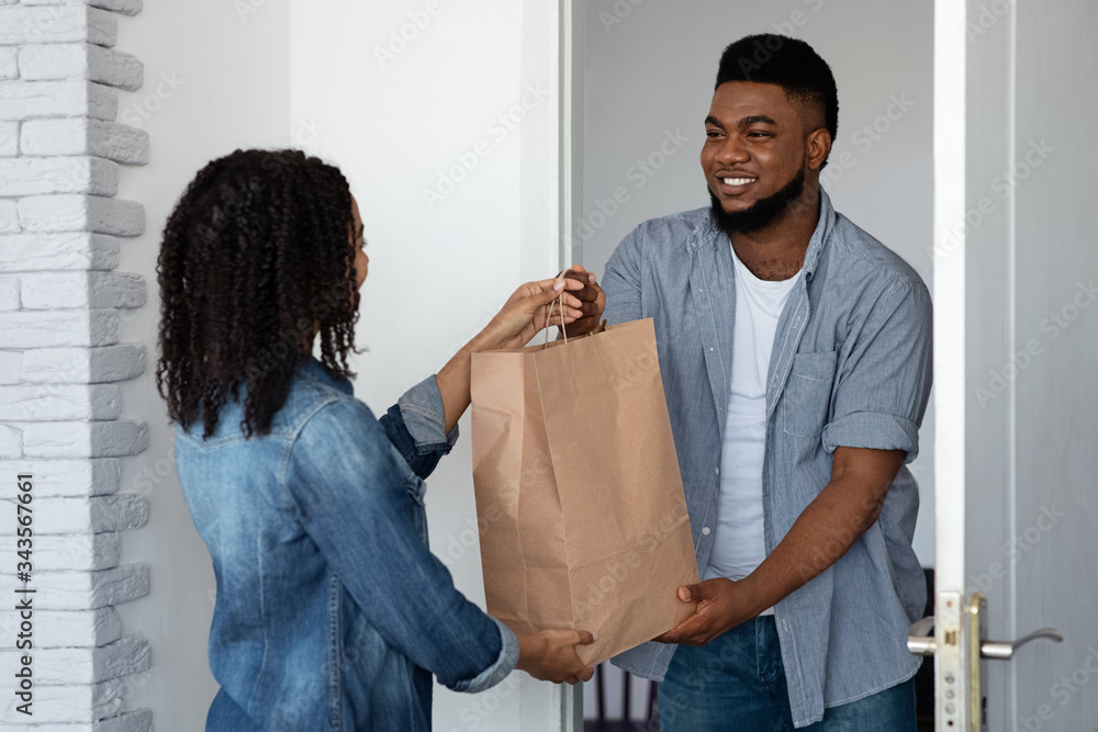 Grocery Delivery. Smiling Black Courier Delivering Order To Young Woman ...