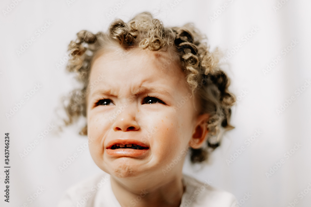 Little curly girl is crying very emotionally, face with tears and ...