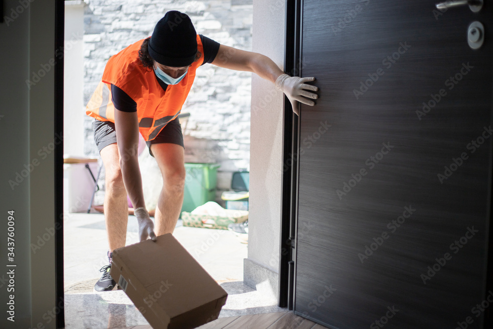 Delivery driver leaving a parcel box on the floor just beyond the open ...