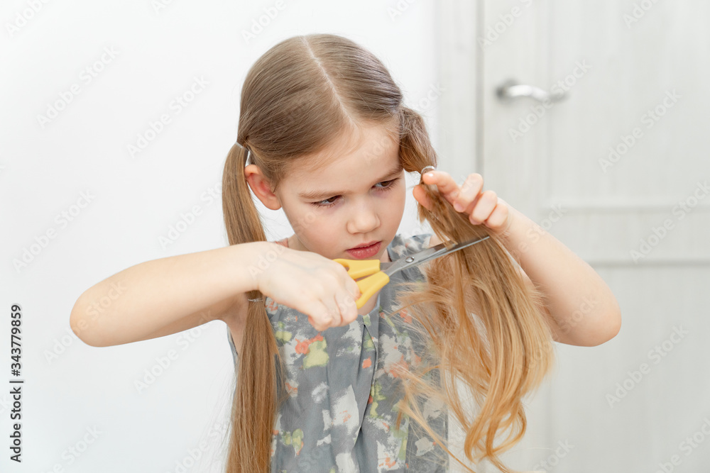 little girl cutting hair to herself with scissors Stock Photo | Adobe Stock