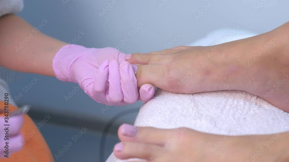 Pedicurist master is wiping painted shellac toe nails using lint-free ...