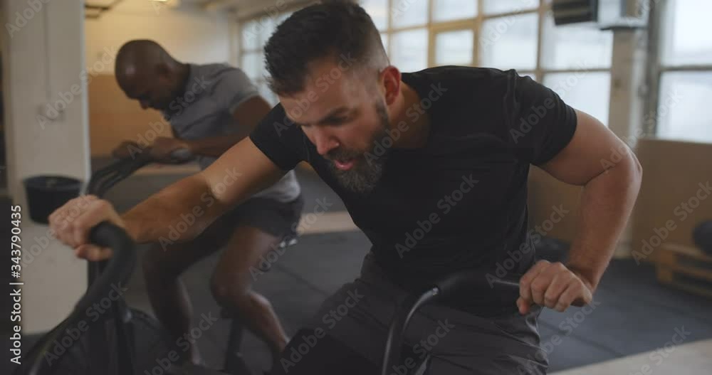 Two fit young men in sportswear finishing a cardio workout on ...