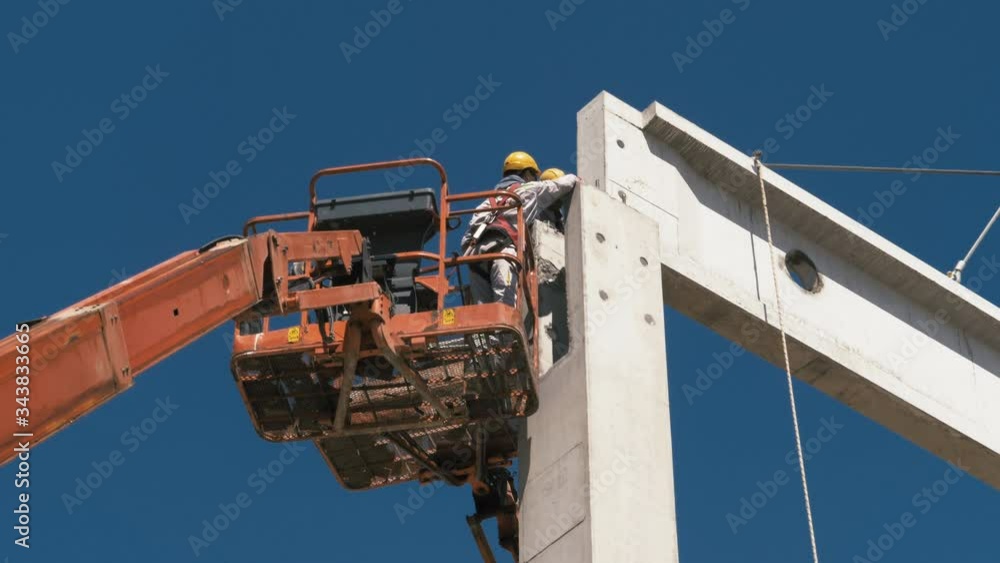 Unrecognizable construction worker in articulated manlift crane ...