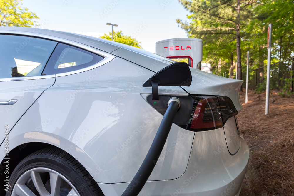 Charging a Tesla Model 3 at a Tesla Stock Photo | Adobe Stock