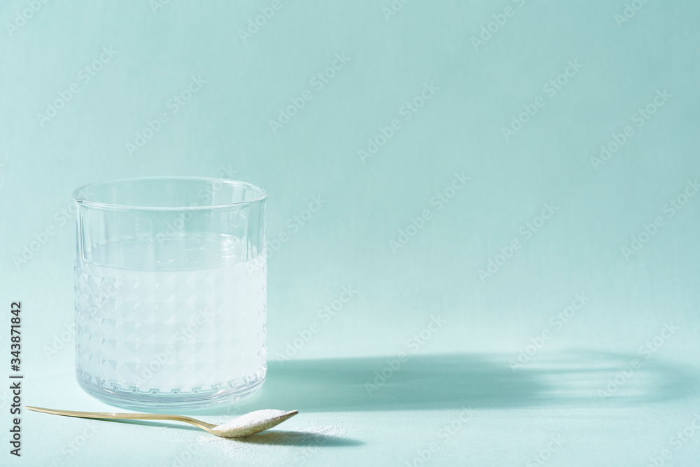 Collagen protein powder a blue background - Hydrolyzed. Spoon and glass ...