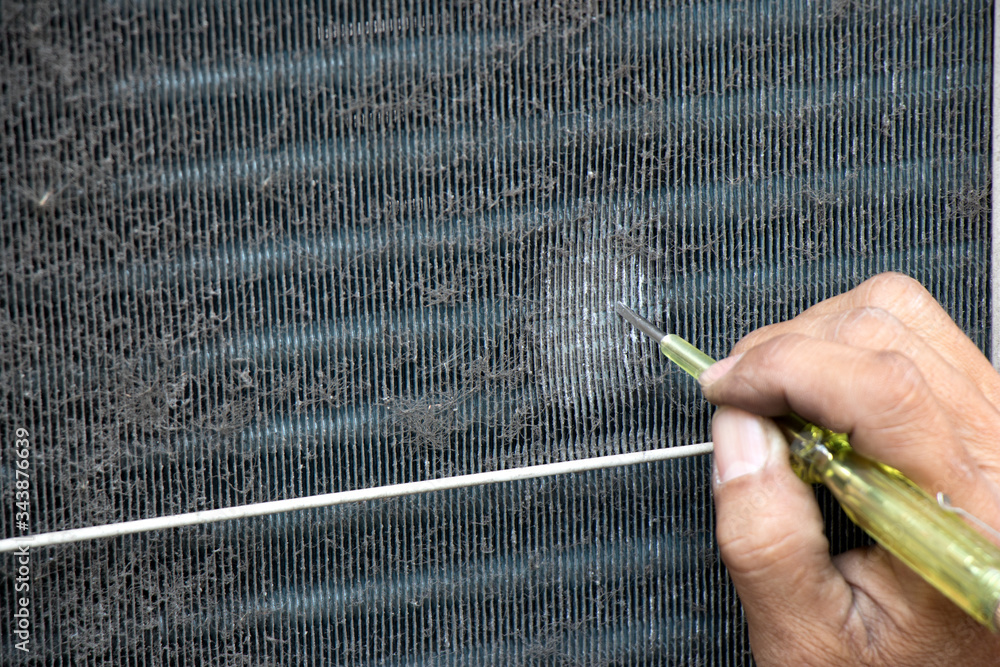 Repairing air-conditioner compressor fin with screw driver. Re-align ...