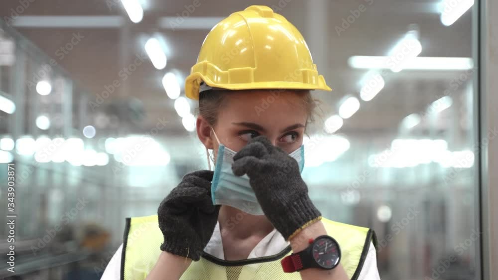 Labor woman worker is wearing protection mask face and safety helmet ...