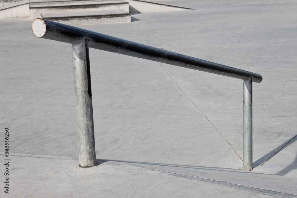 Sloped metal rail for grind tricks in an empty concrete skatepark Stock ...