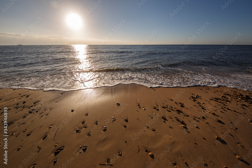 Foto de bagnasciuga in un spiaggia con risacca delle onde al tramonto ...
