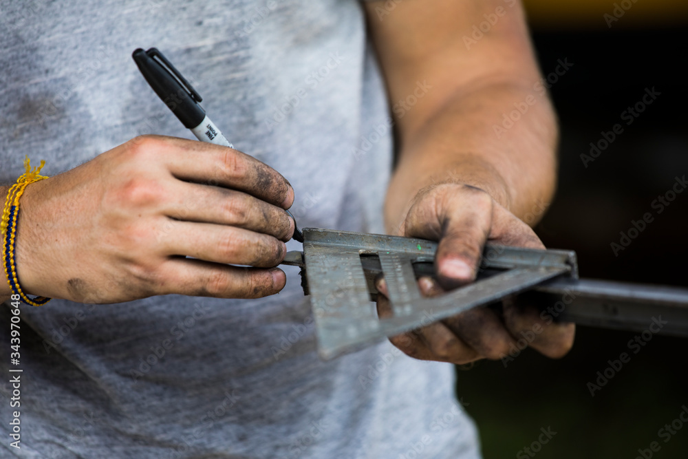 Construction worker using speed square to measure angle on steel. Stock ...