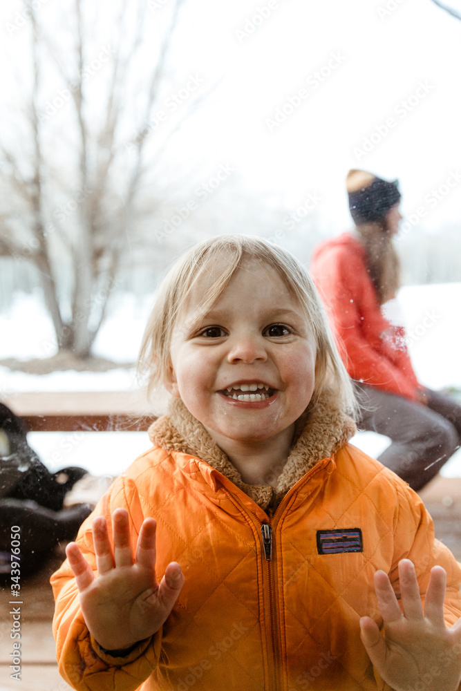 wide eyes smiling 3 year old girl looks through window pane at uncle ...