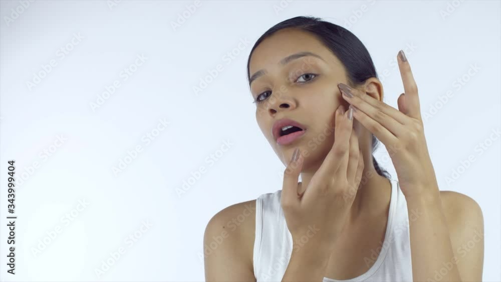 Video „Unhappy young female looking at her skin condition while ...