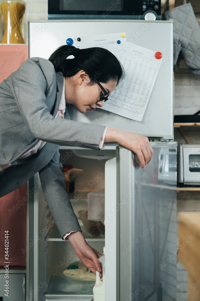 asian career woman bending over is craving drink and taking milk from ...