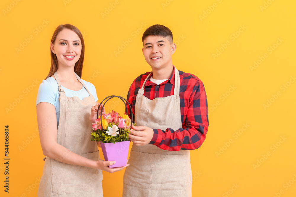 Portrait of florists with bouquet on color background Stock Photo ...