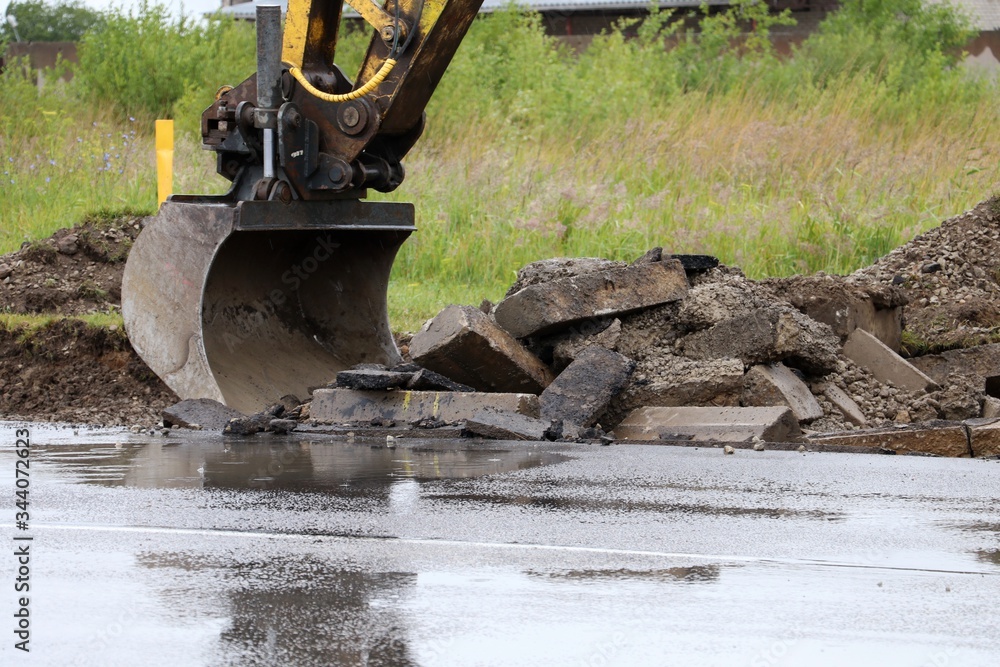 Road construction. Digging asphalt with an excavator. Stock Photo ...