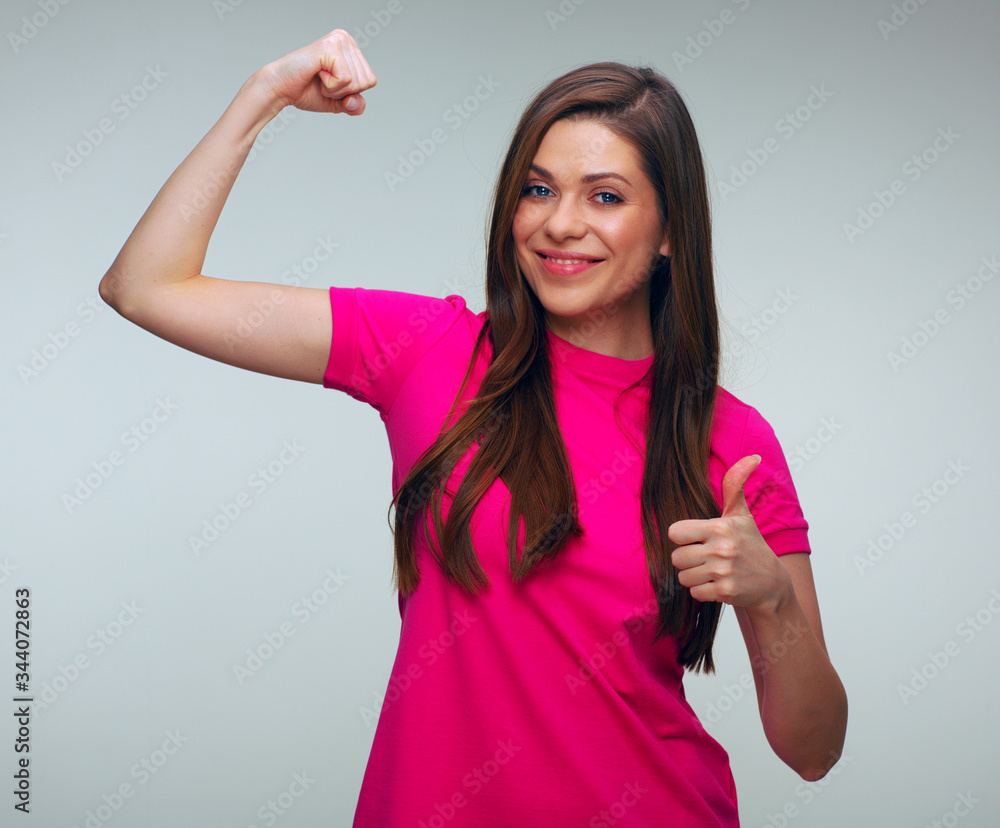 concept portrait with girl flexing one arms muscles and showing thumb ...
