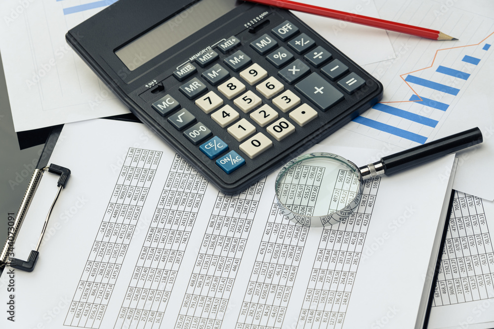 Business financial documents, office calculator and pen on the table ...