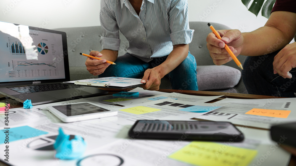 Business people writing on sticky notes for colleagues thinking ...