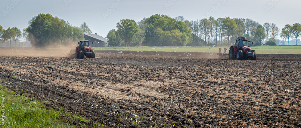 Draught. Farming. Tractors ploughing and harrowing at very dry fields ...