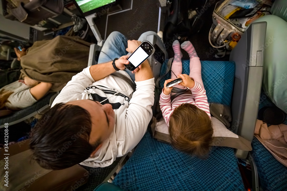 entertainment on board the aircraft in flight. dad and baby are sitting ...