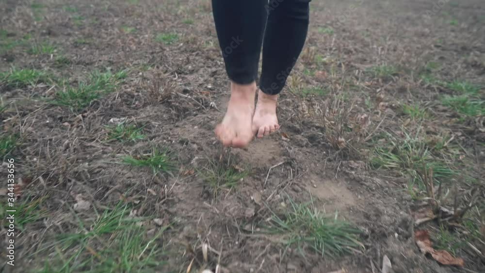 Video „Bare feet walk on the bare ground. Feet without shoes. A girl ...