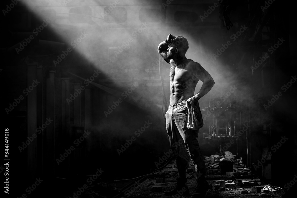 Foto de strong man against fog at factory exhausted stands, press and ...