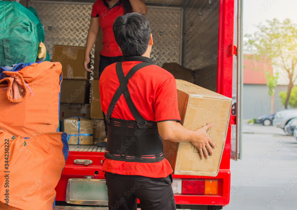The man lifts the parcel box into the car to prepare to transport for ...