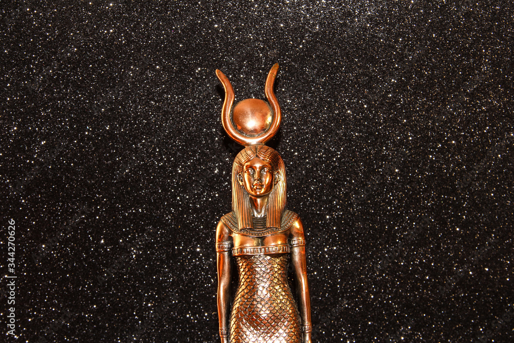 The Egyptian goddess ISIS on a black background. A bronze Egyptian ...