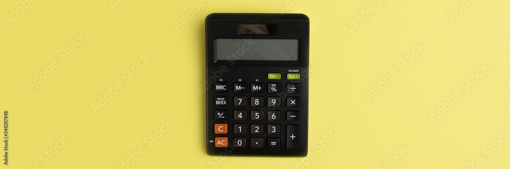 Black minimal calculator on solid yellow background for financial ...