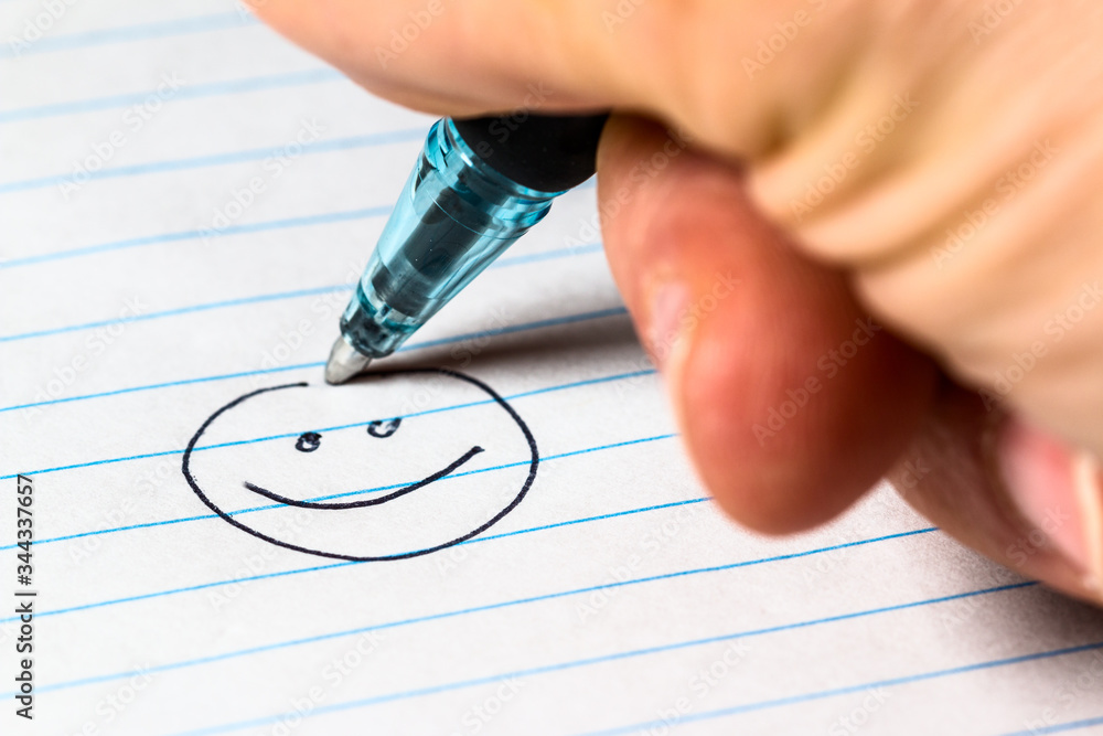 Foto de Drawing a smiley face with a pen onto a piece of paper do Stock ...
