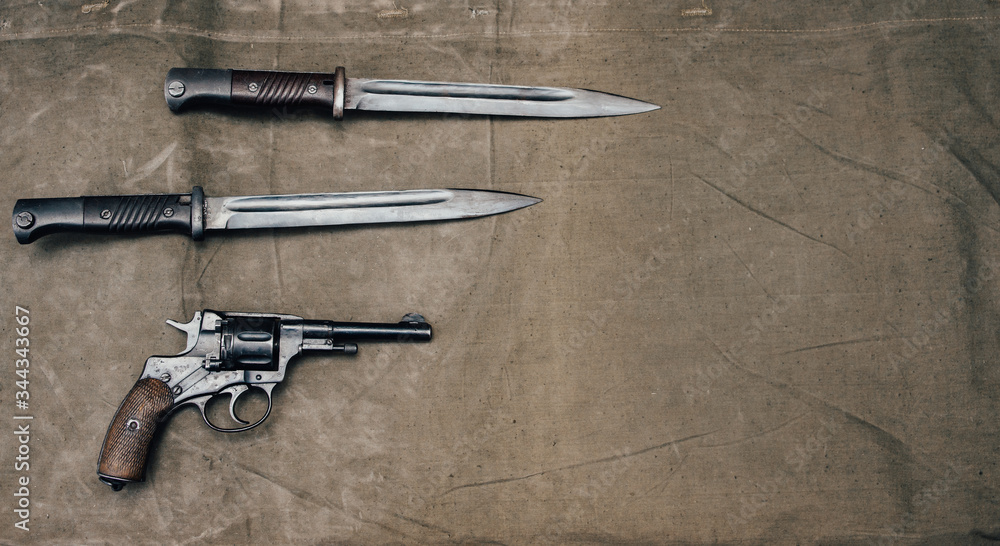 Bayonet knife with revolver Nagan system on an old surface in retro ...