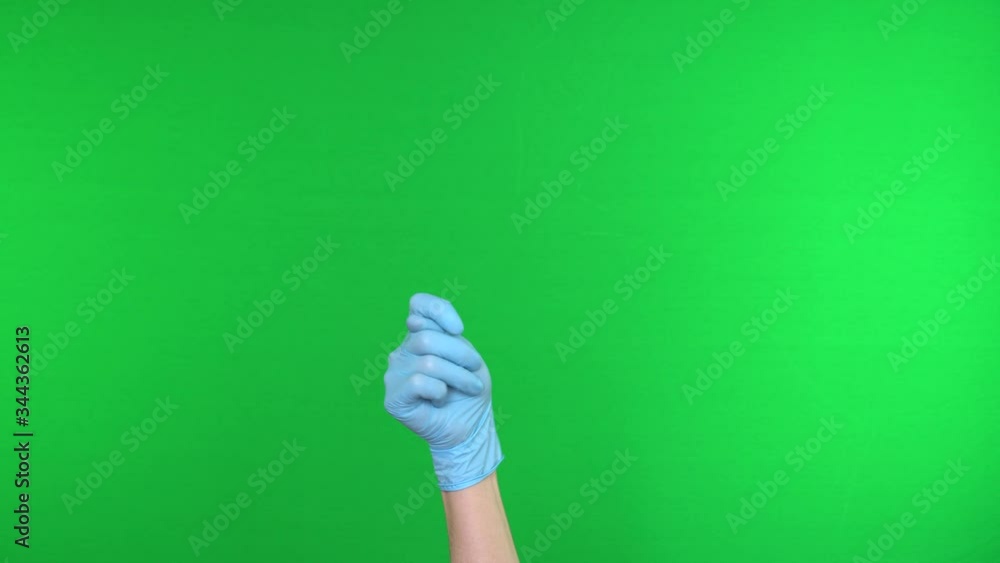A hand in medical gloves making the hand-sign with the thumb wedged ...