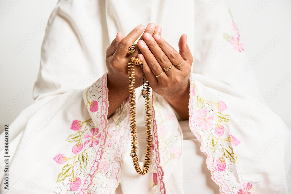 Muslim woman praying close up image of hands as she holds prayer beads ...