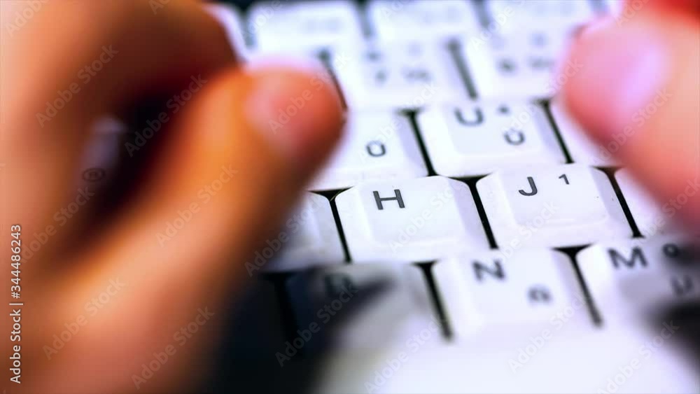 Video Stock Man writing, quickly typing on an old white laptop keyboard ...