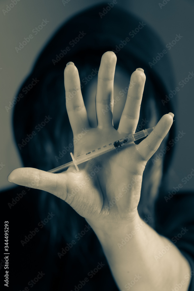 black and white shot man holds a syringe in an open palm in front of ...