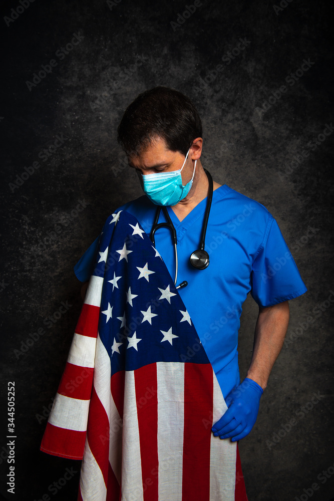 Sad/pensive male doctor in blue hospital scrubs with face mask and ...