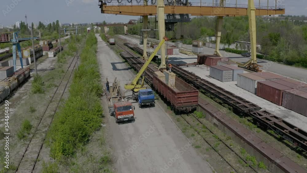 Aerial view of railroad by overhead cranes. The mobile crane loads the ...