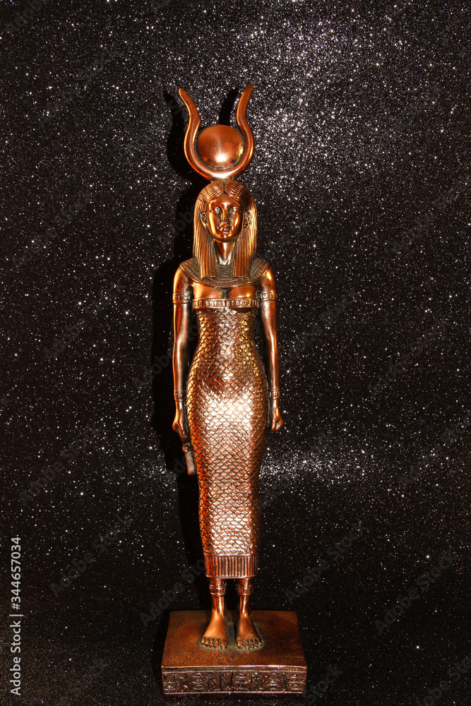 The Egyptian goddess ISIS on a black background. A bronze Egyptian ...