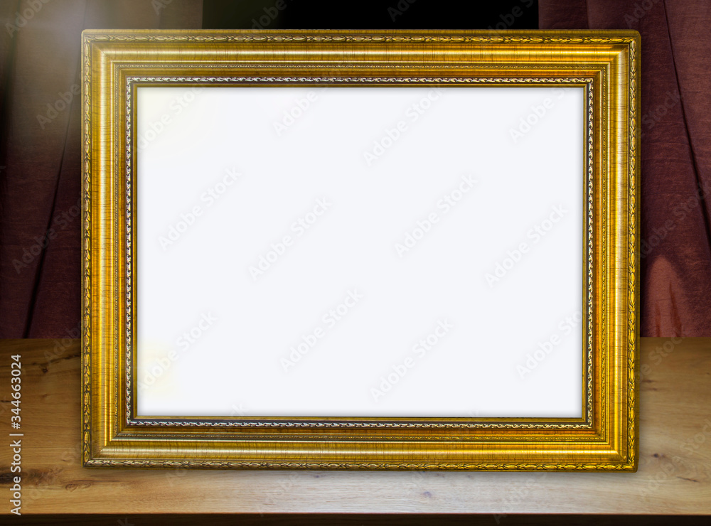 Wooden table, gold frame, dark background and drapery. Free space for ...
