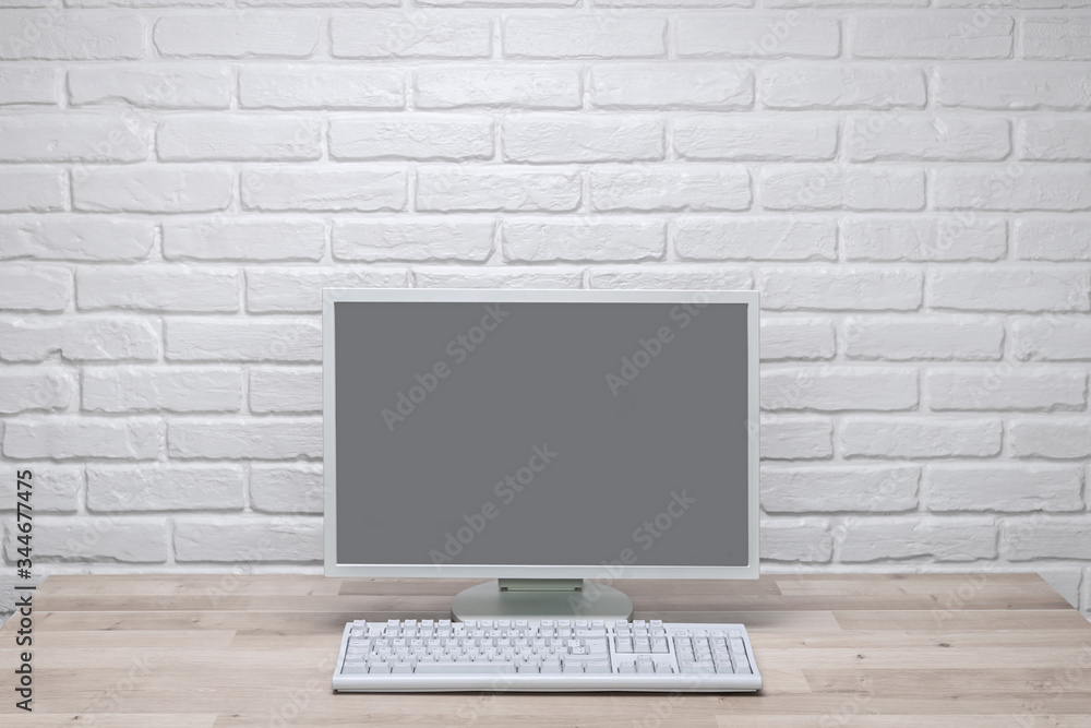 Blank screen computer monitor on working desk with brick wall Stock ...