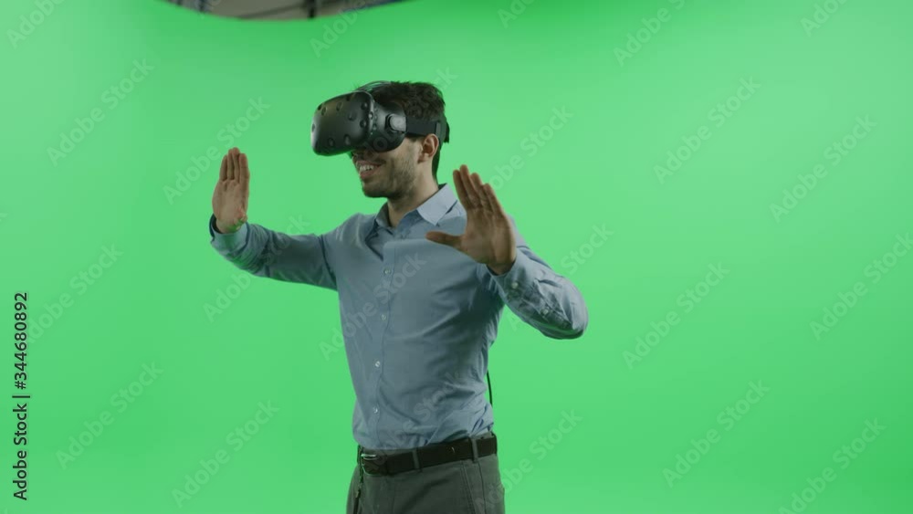 Green Screen Chroma Key Studio: Man Using Virtual Reality Headset for ...