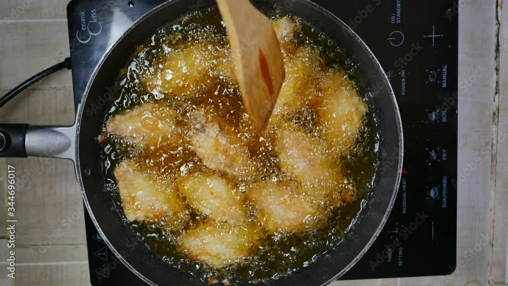 fried chicken with bubble boiled food palm oil in induction pan on ...