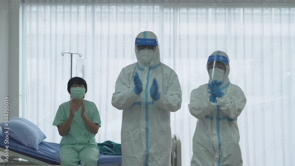 Asian doctor and nurse in personal protective equipment or ppe with ...