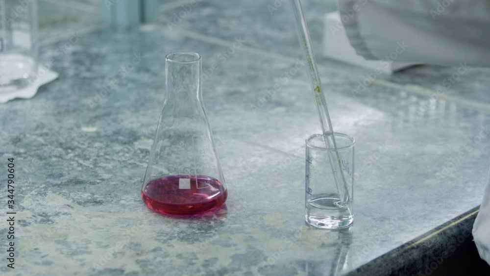 operator takes a sample of water or solution in a measuring tube in ...