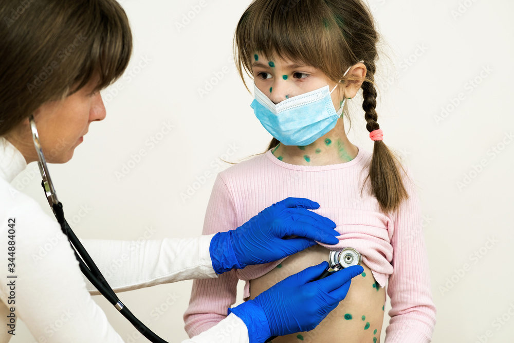 Doctor examining child girl covered with green rashes on face and ...