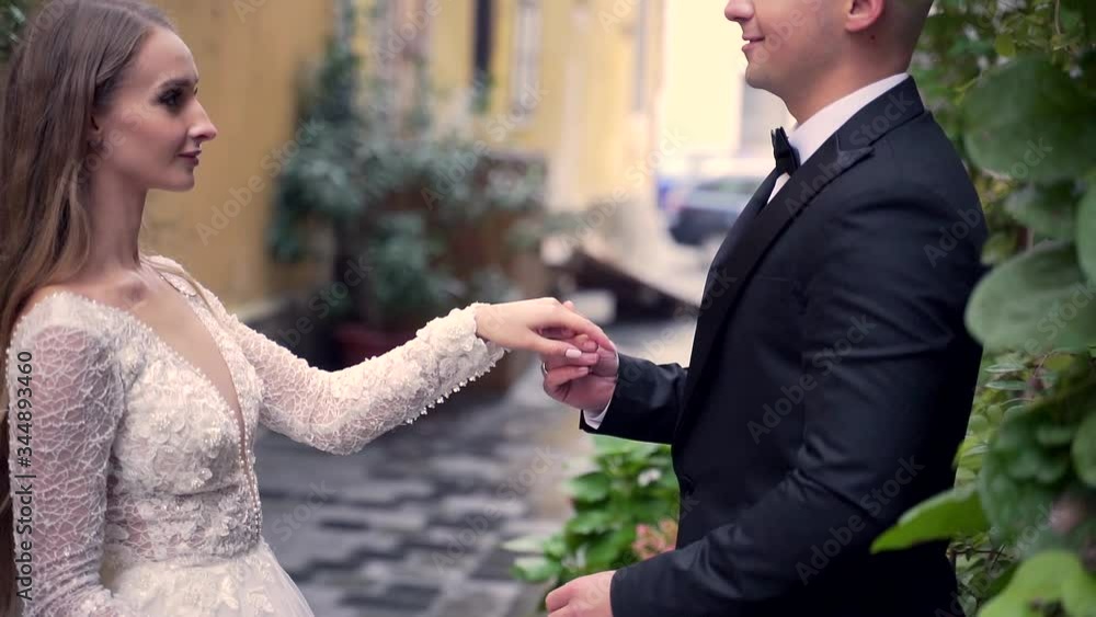 loving young wedding couple, bride in white dress, groom in black suit ...